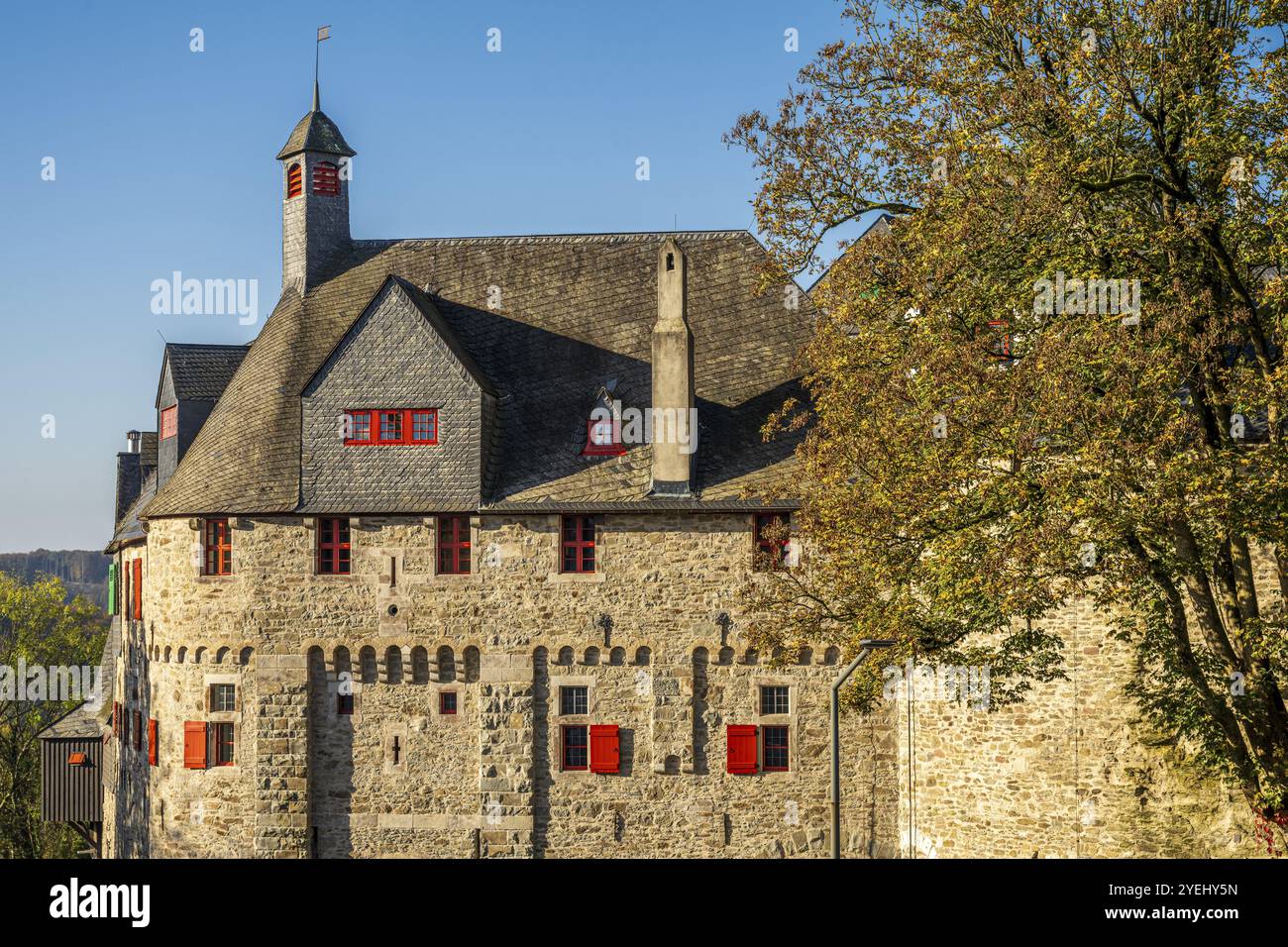 Expansive medieval castle with red windows in autumn light, Burg Castle ...