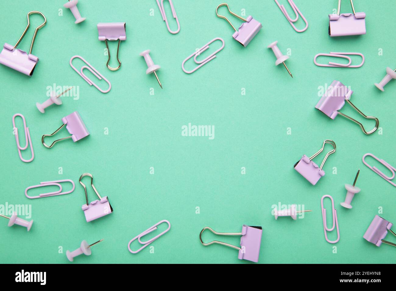 Set of purple paper clips, binders and pins on mint background. Top ...