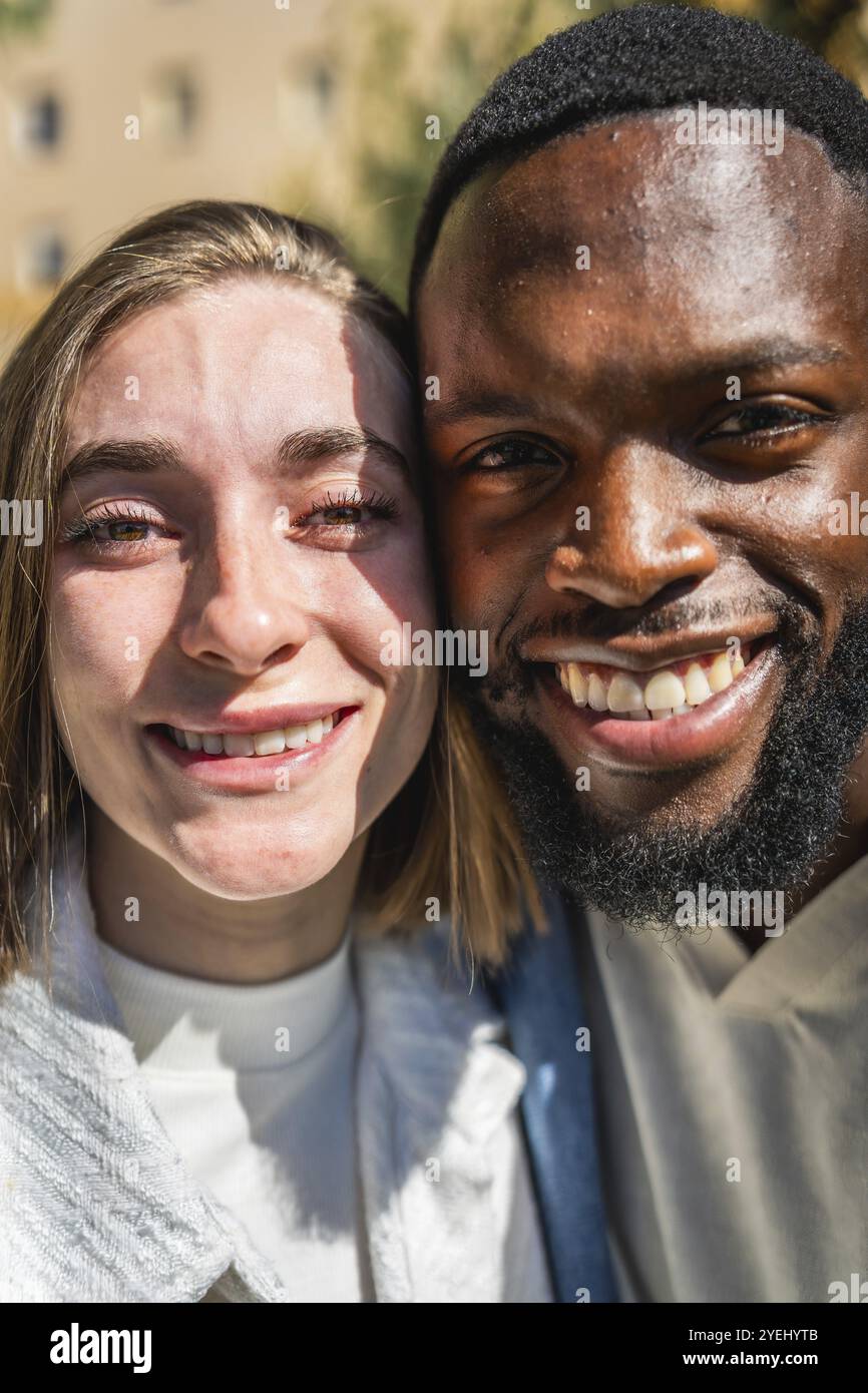 Vertical close-up portrait of a smiling multiracial young couple ...