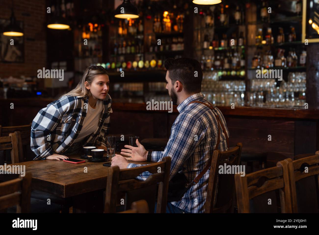 Bartender life. Two young bartenders argue about coffee taste and ...