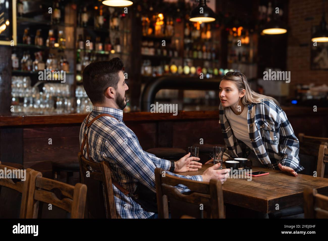 Bartender life. Two young bartenders argue about coffee taste and ...