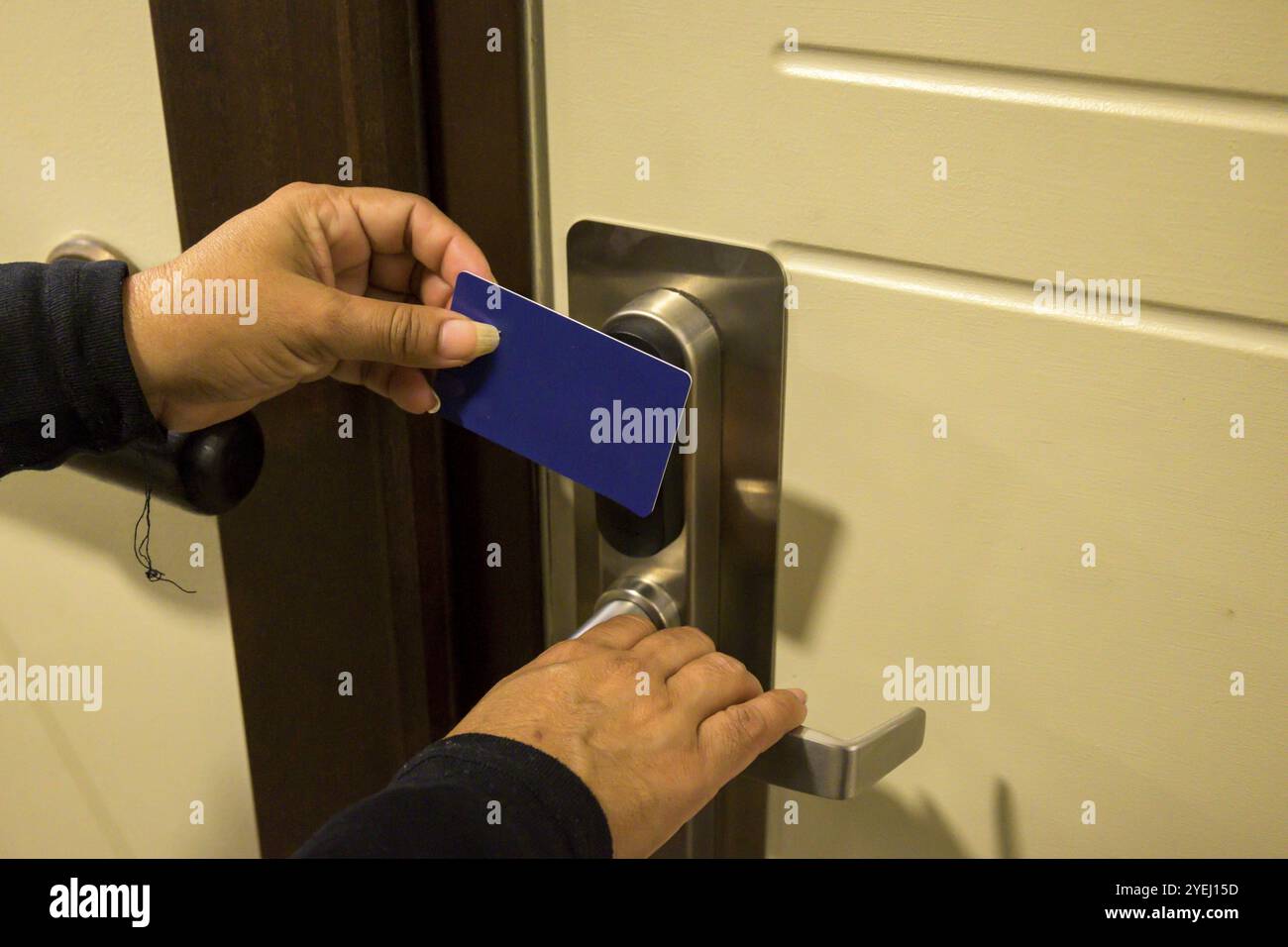 Hands holding a keycard near a door lock for entry, key electronic lock ...