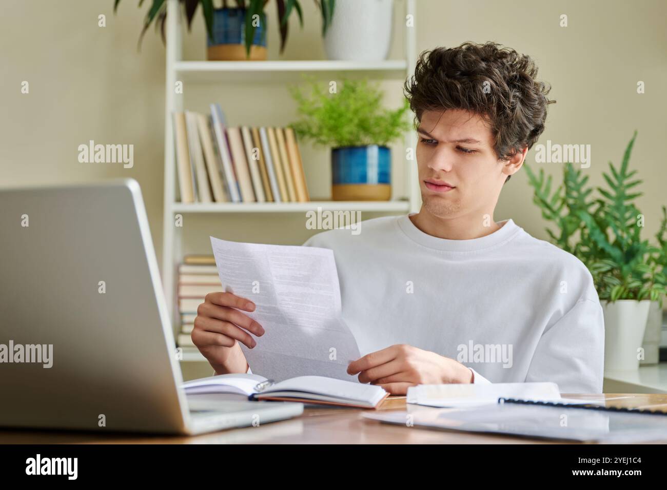 Serious young guy reading letter, paper document Stock Photo - Alamy