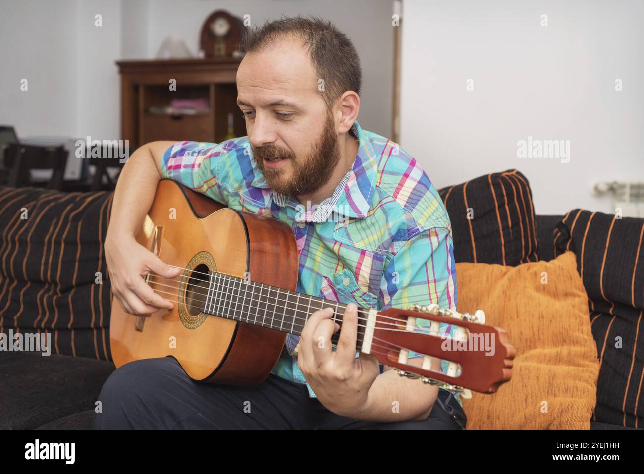 Young man tuning acoustic guitar hi-res stock photography and images ...