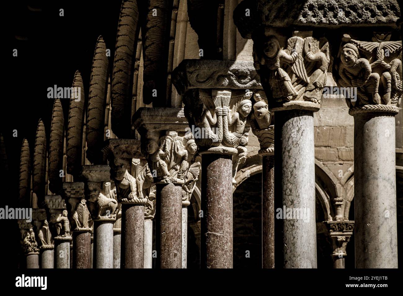 Medieval stone columns with intricate carvings and arches create a ...