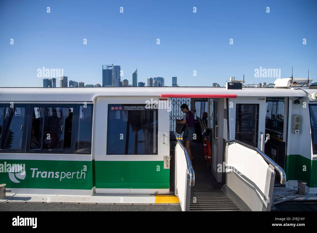This photo captures a Transperth ferry docked at the waterfront, with ...