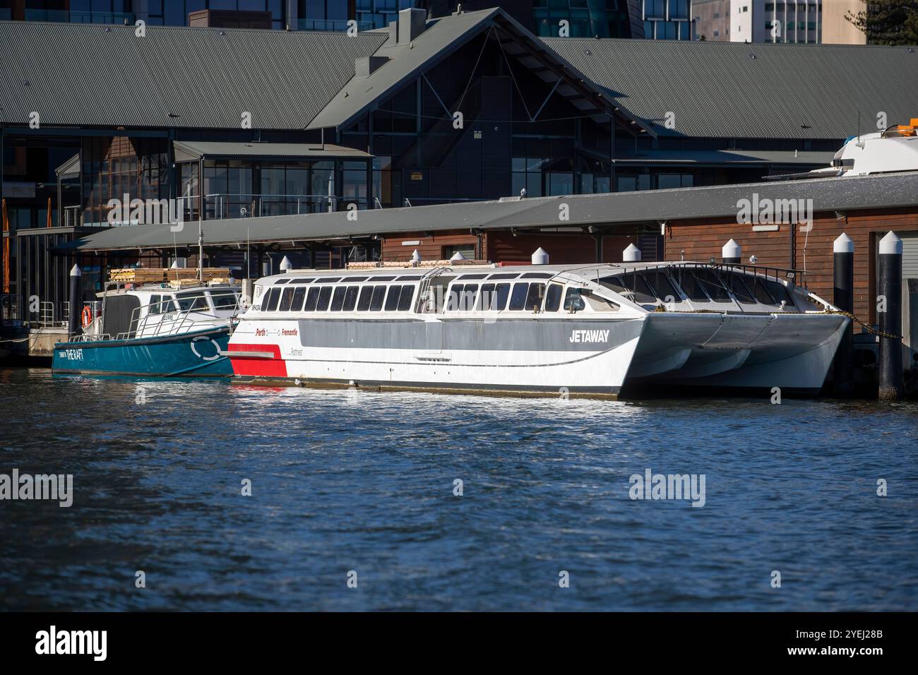 This image features two boats docked at a marina in Perth, with a ...