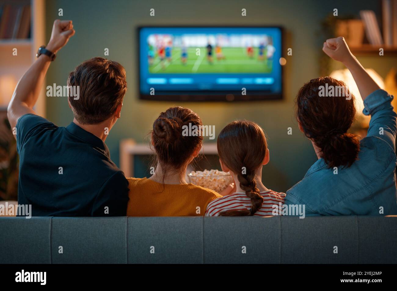 Happy family watching sport with popcorn in the evening at home Stock ...