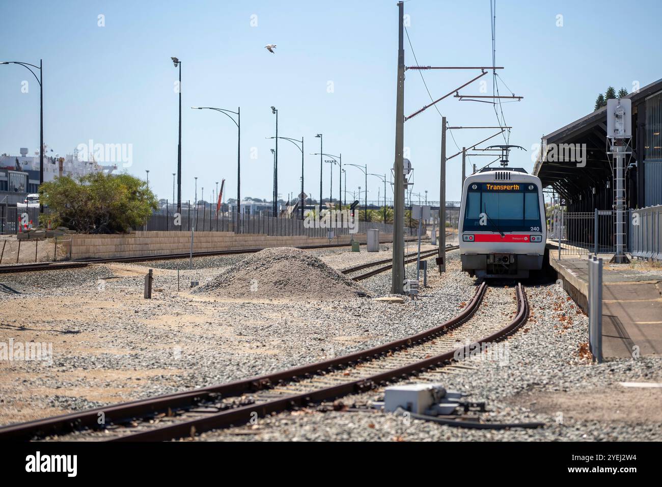 A Transperth train stopped at a railway station under sunny conditions ...