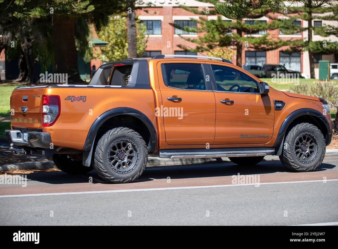 The image shows an orange Ford Ranger Wildtrak 4x4 pickup truck parked ...