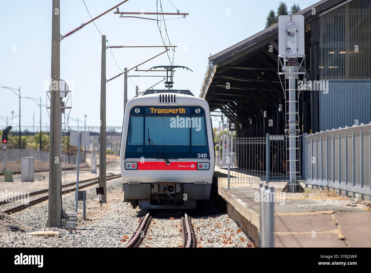 A Transperth train stopped at a railway station under sunny conditions ...