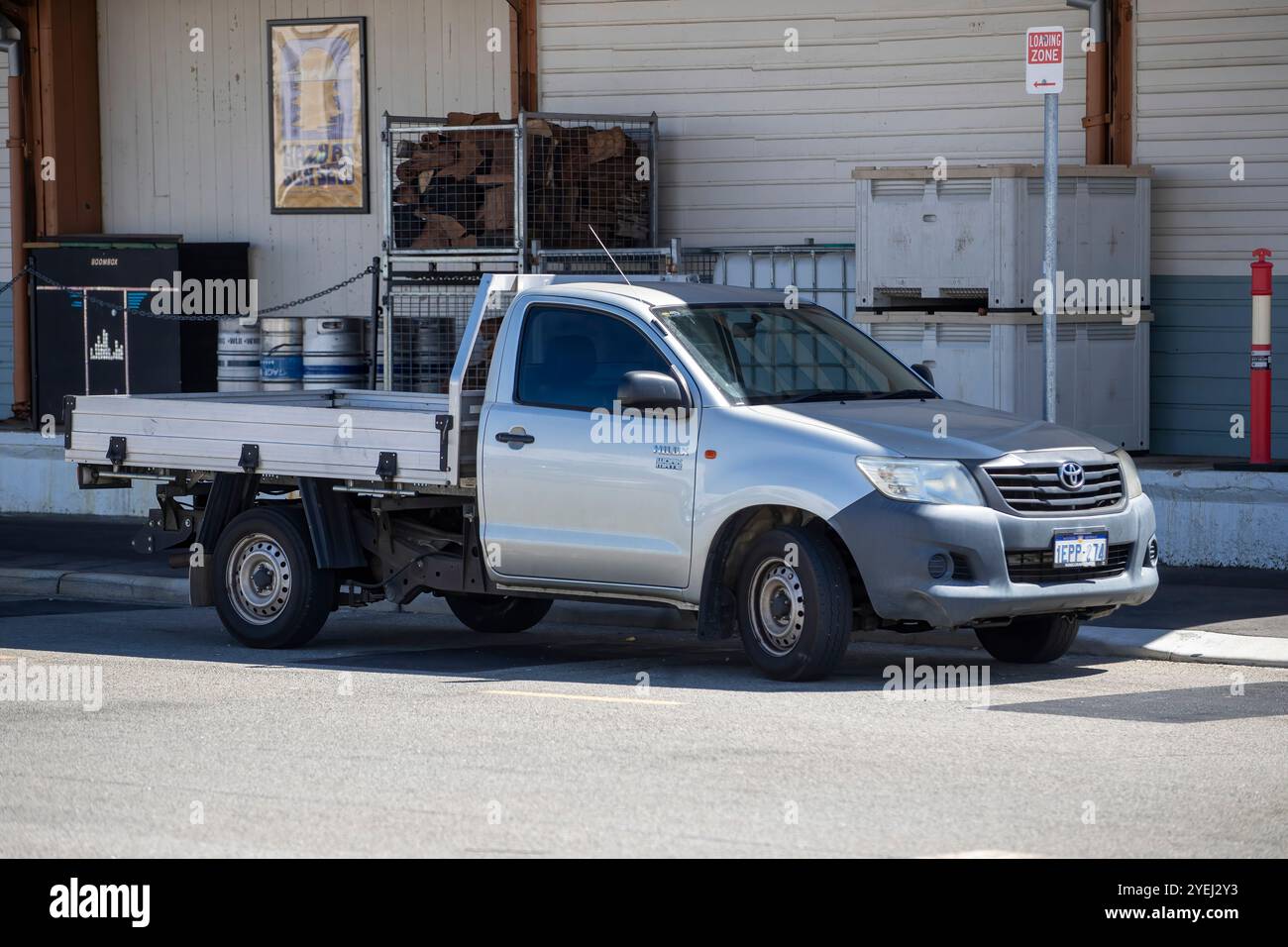 The image depicts a silver Toyota Hilux utility truck parked in a ...