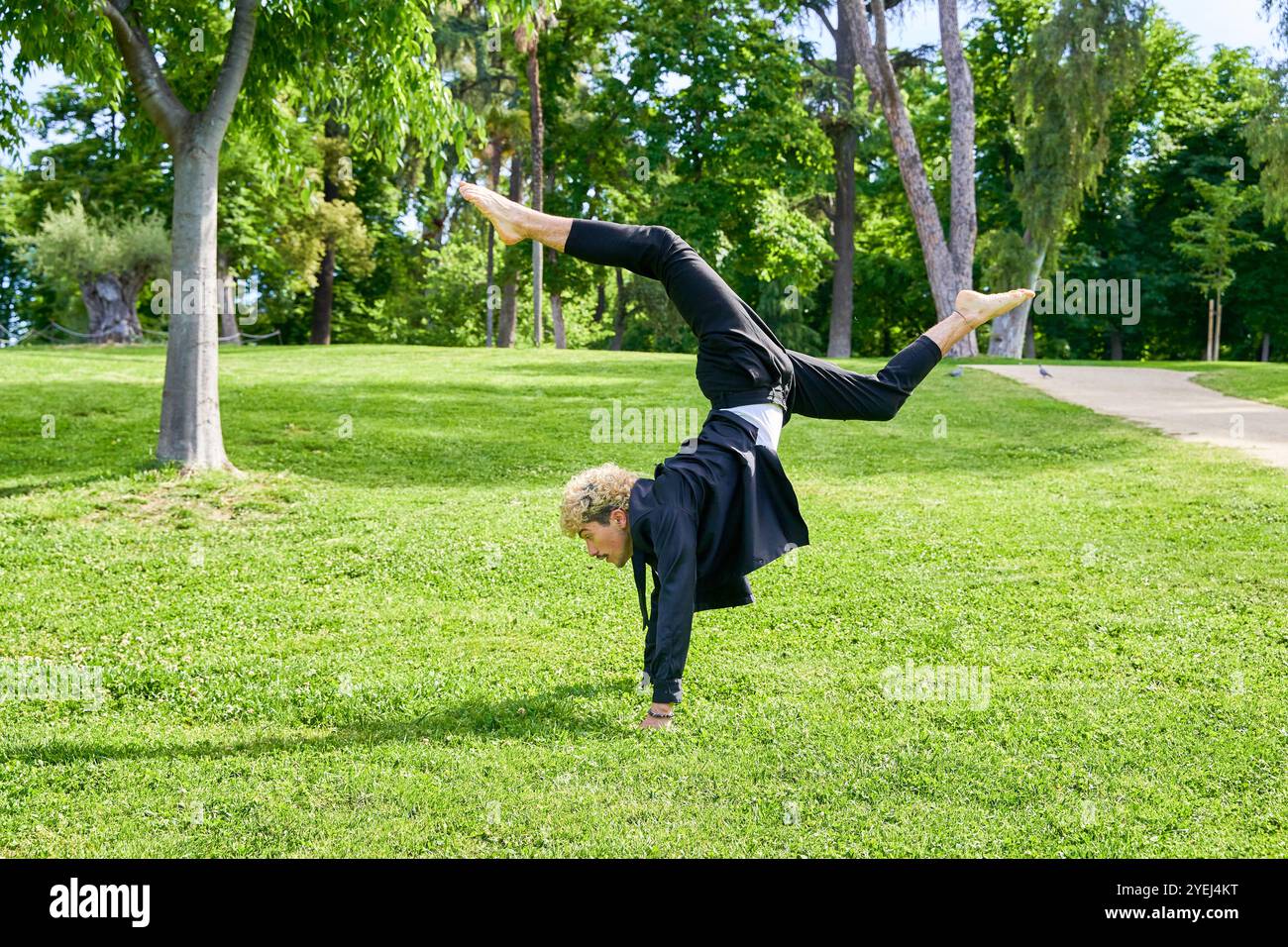 young man jumping and dancing contemporary ballet in the park with ...