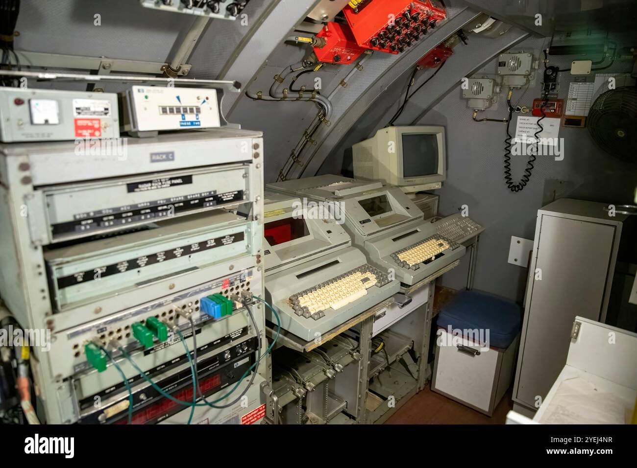 This image depicts a control station with vintage computers and ...