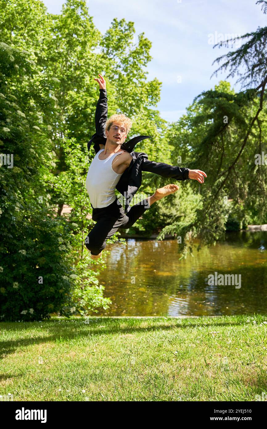 young man jumping and dancing contemporary ballet in the park with ...