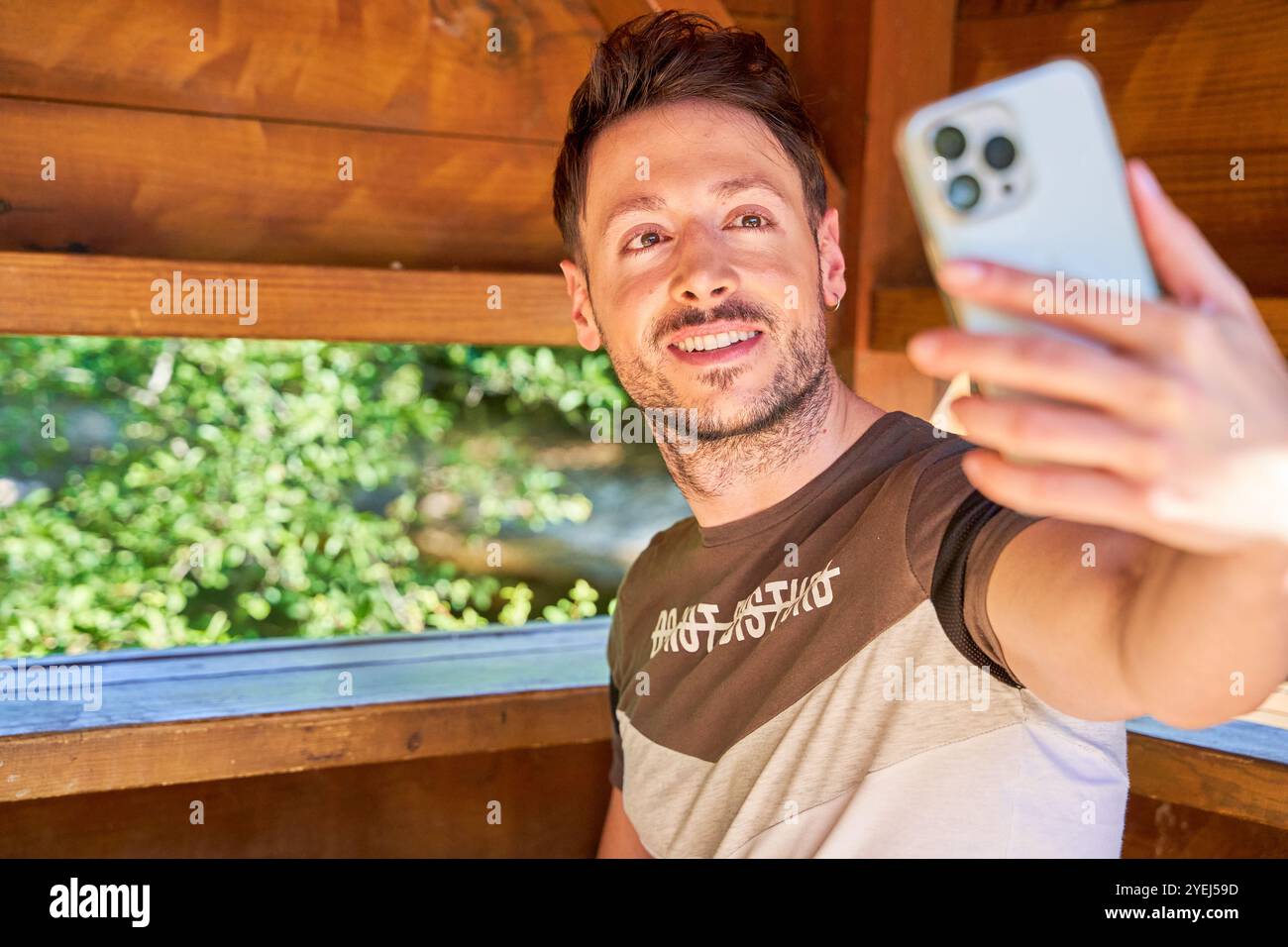 man looking at birds at a bird lookout, uses his smart phone to take a ...