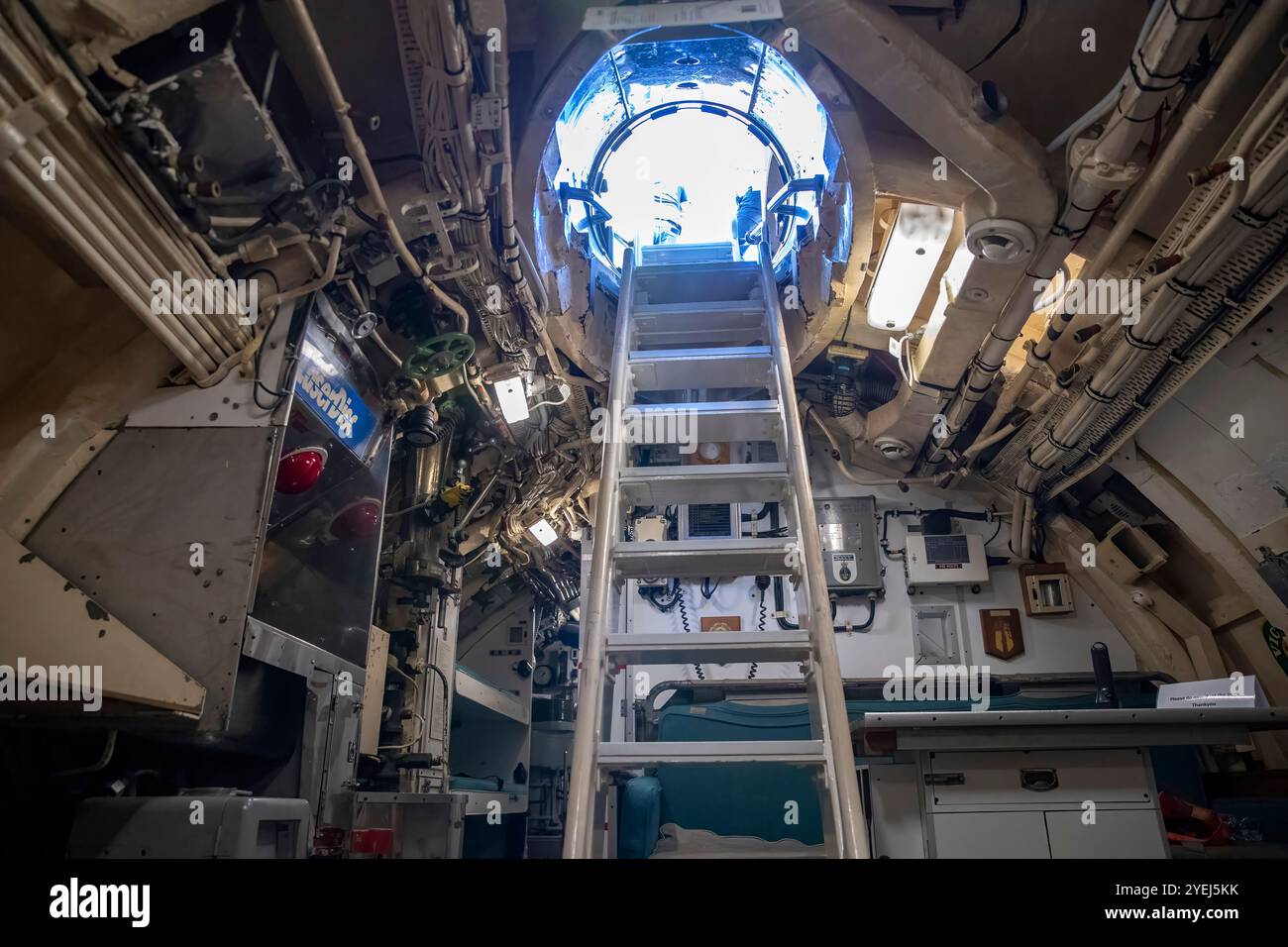 This photograph shows the interior of a submarine, featuring a ladder ...