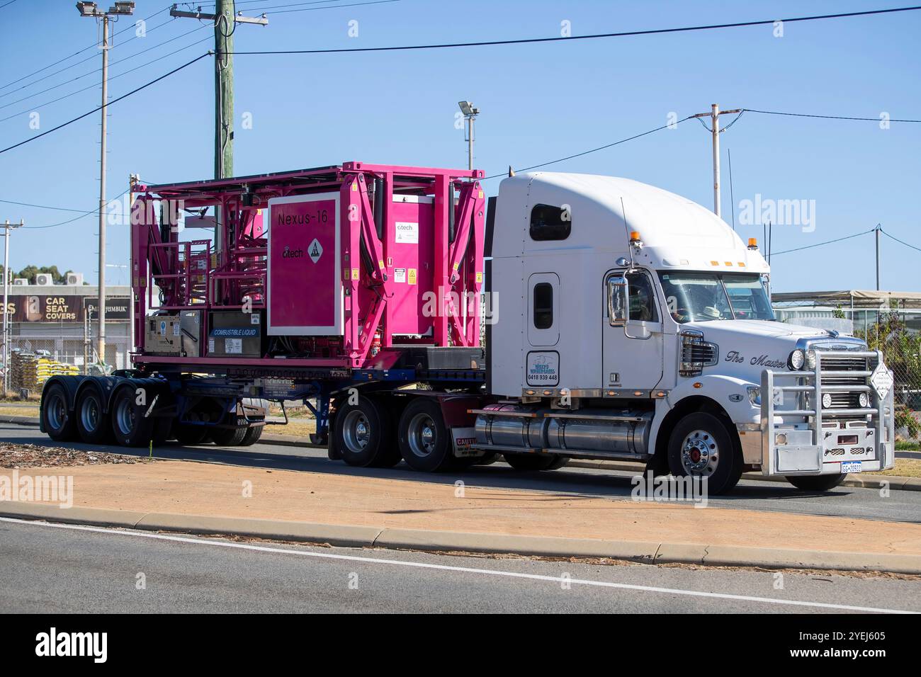 white semi-trailer truck hauling a vibrant pink container labeled ...