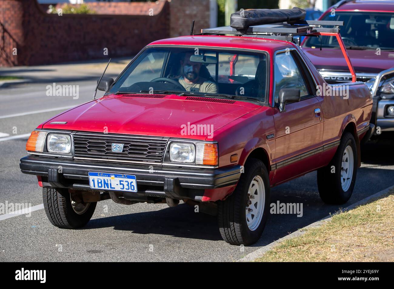 A red Subaru Brumby parked on the side of a suburban road Stock Photo ...