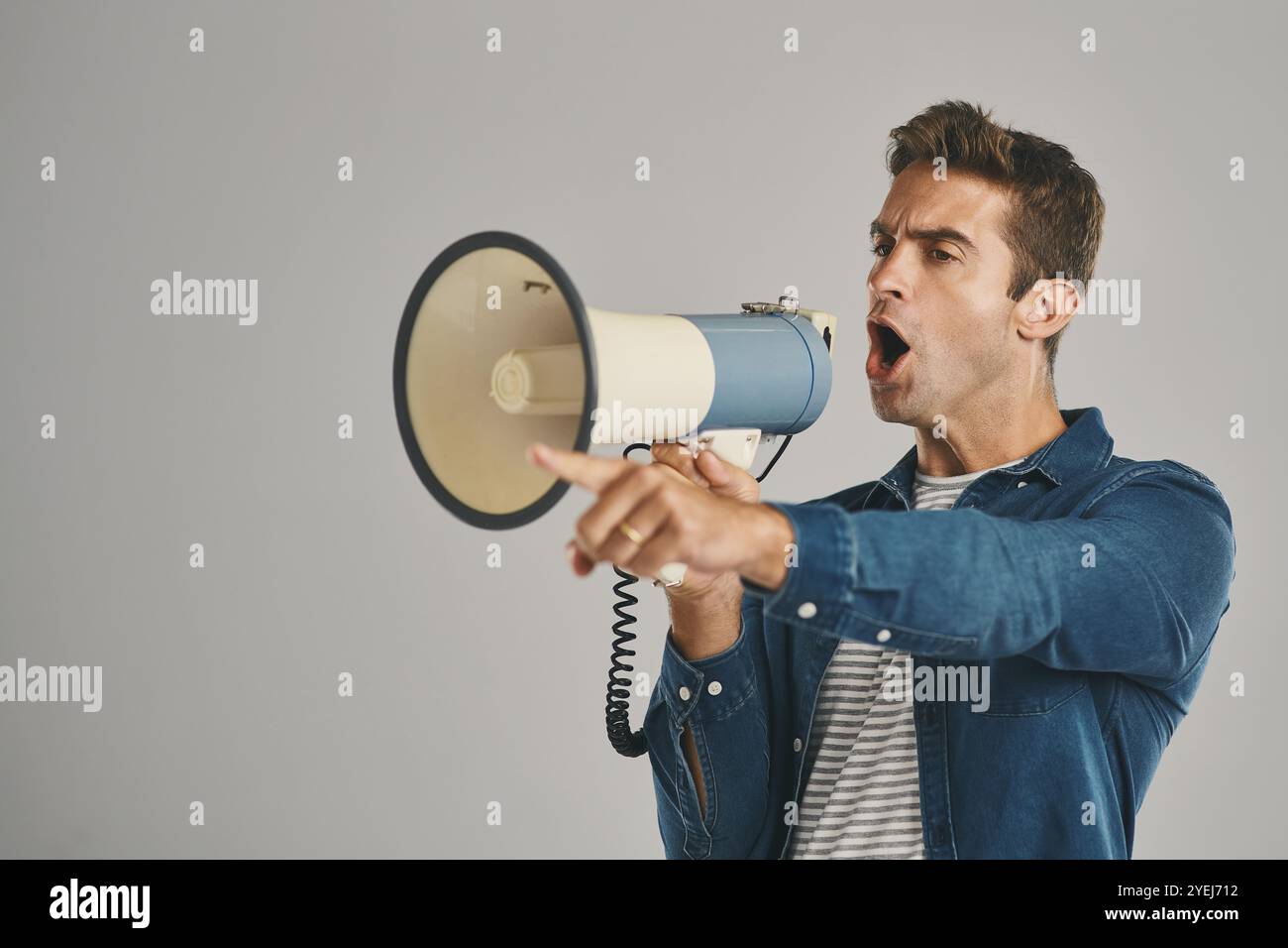 Man, shout and megaphone with choice in studio of communication ...