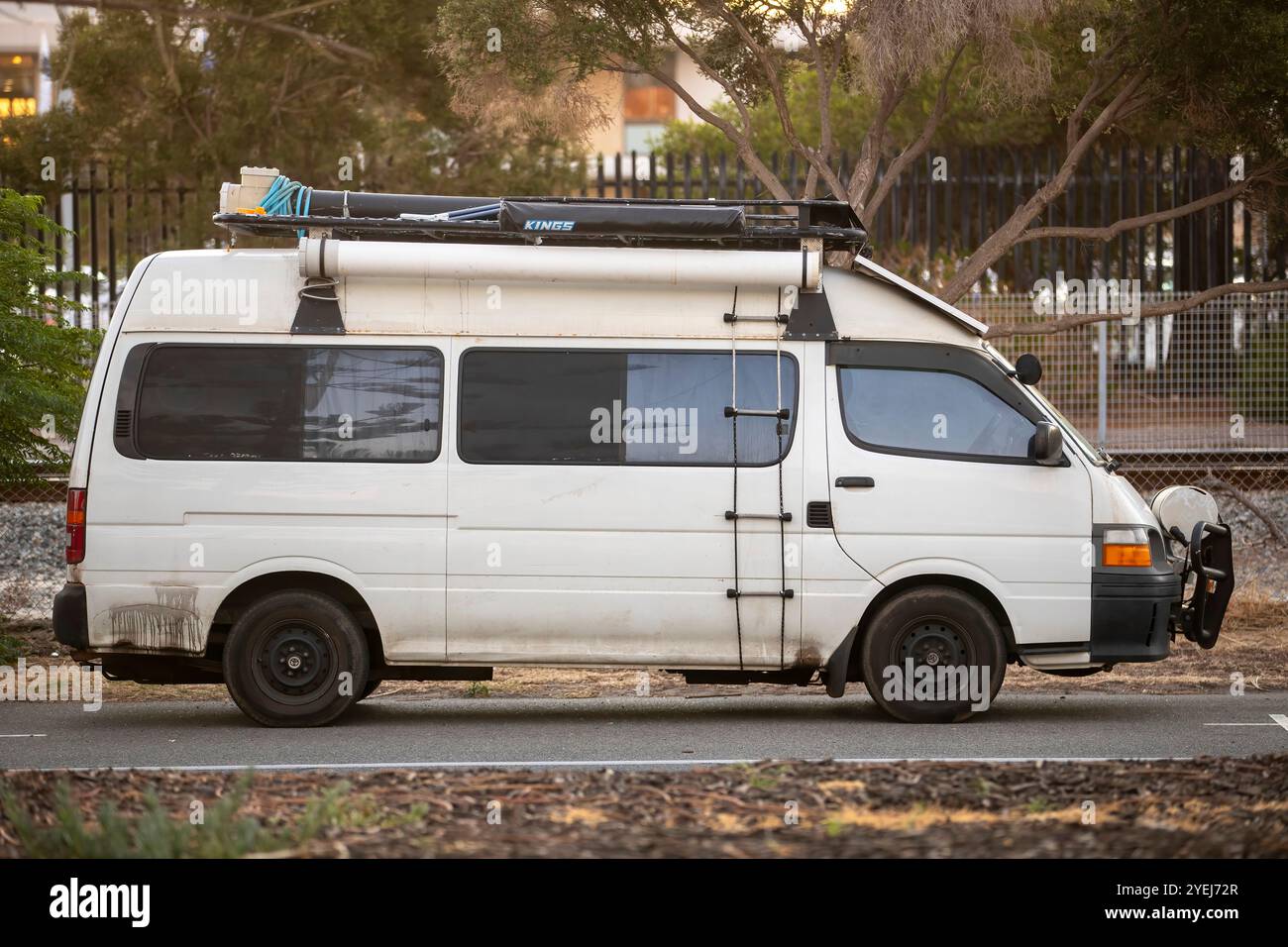 Toyota HiAce Camper arked on a suburban road, featuring a plain design ...