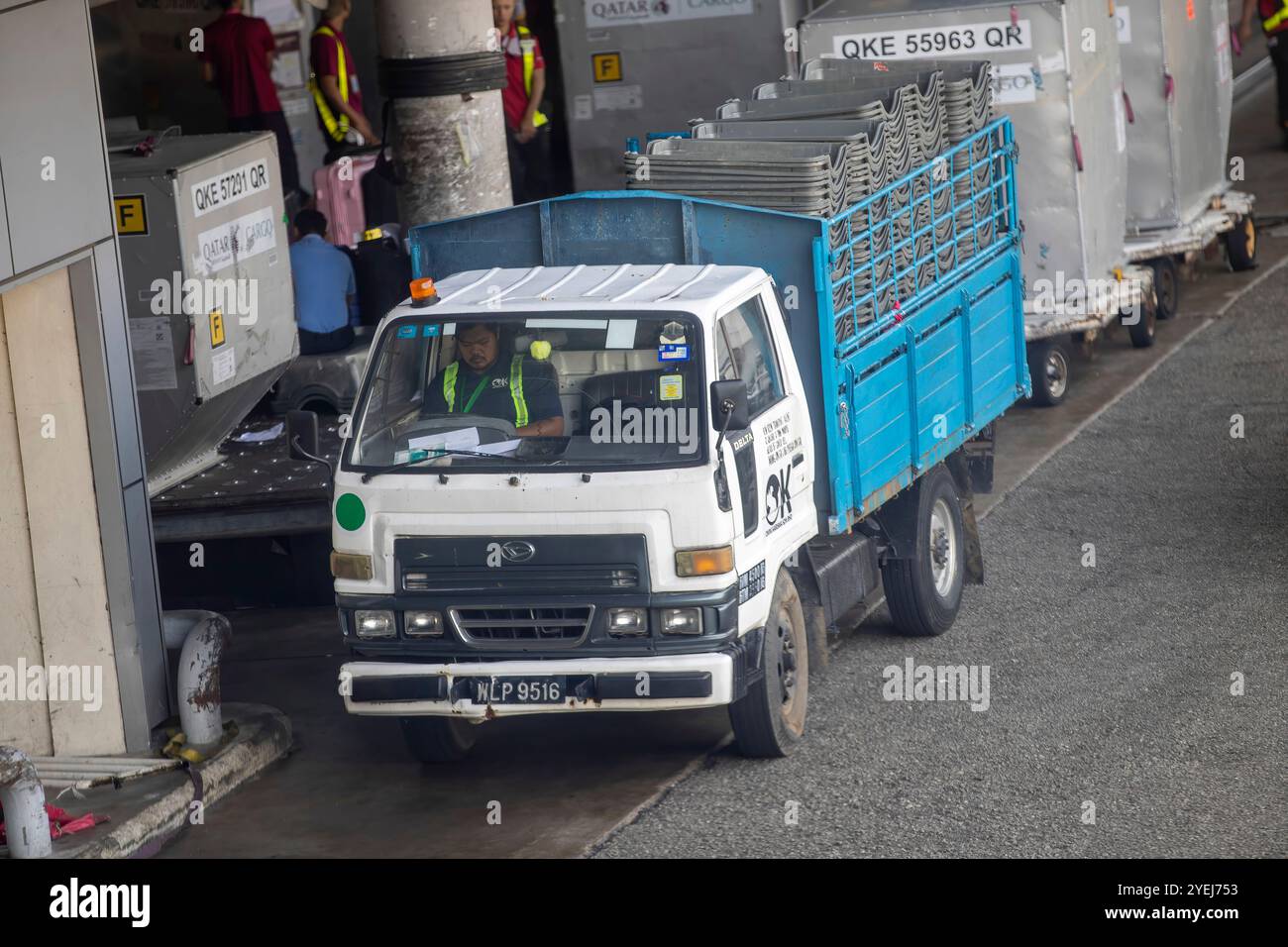 A worker operating a white truck Daihatsu Delta with a blue cargo bed ...