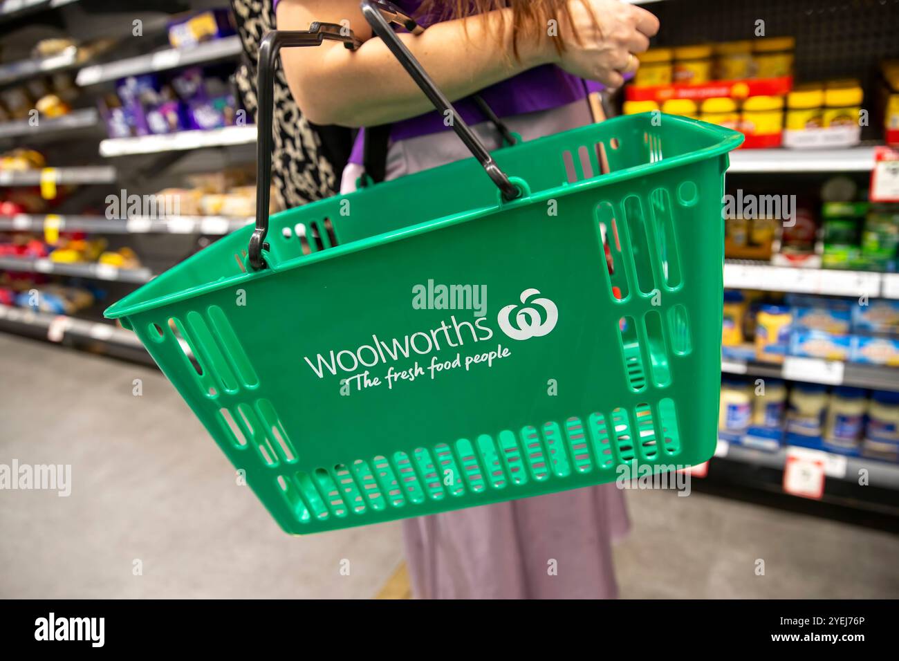 A close-up shot of a Woolworths shopping basket being held by a shopper ...