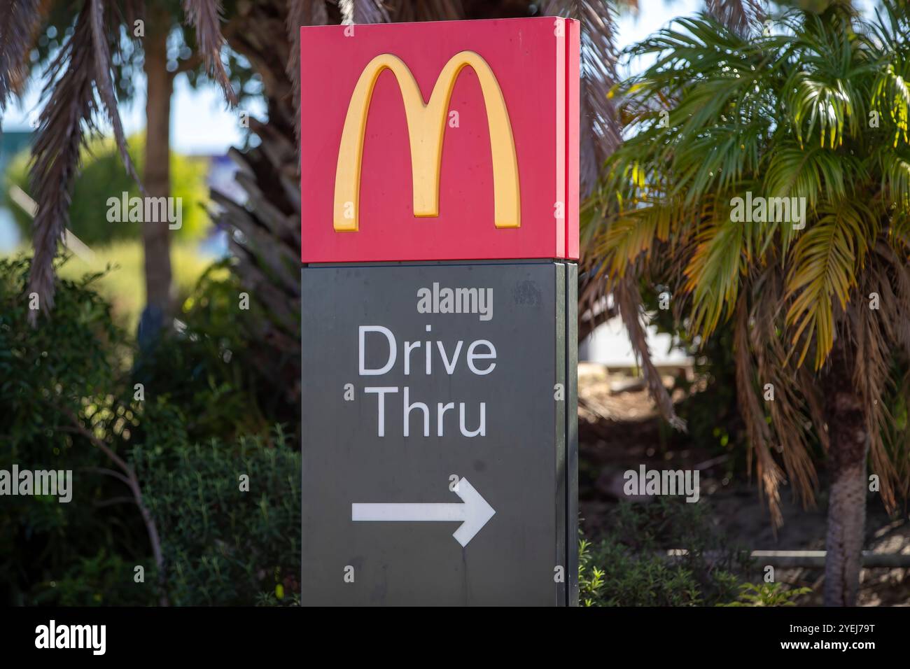 A McDonald's drive-thru sign with the iconic golden arches and a ...
