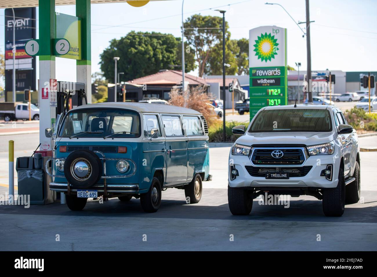 A blue vintage Volkswagen Kombi van and a modern white Toyota Hilux ...