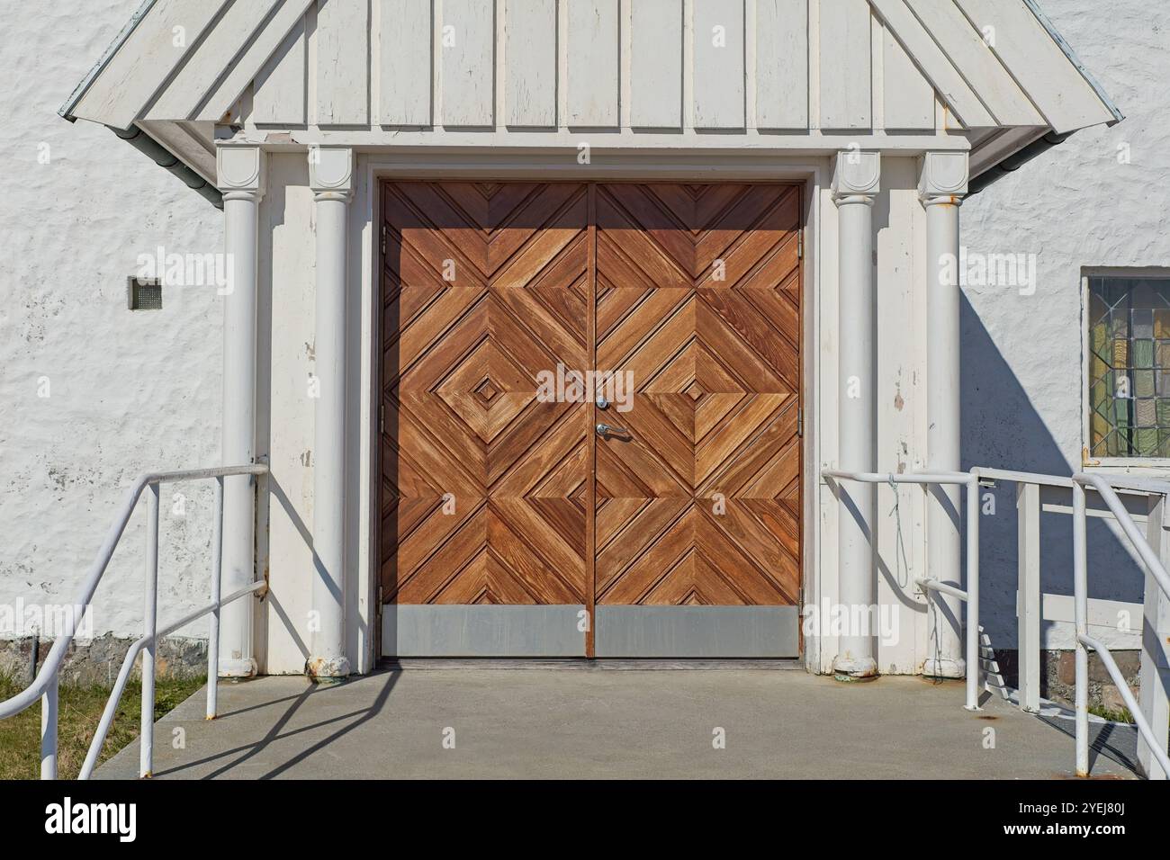 Wooden double doors and pillars on front porch on a stone building ...