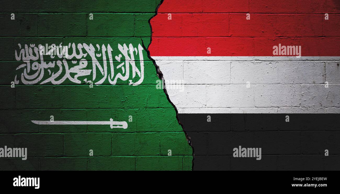 Cracked cinder block wall painted with a Saudi Arabian flag on the left ...