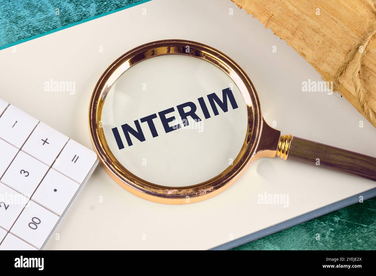 A word INTERIM on a blank page of a business notebook through a ...