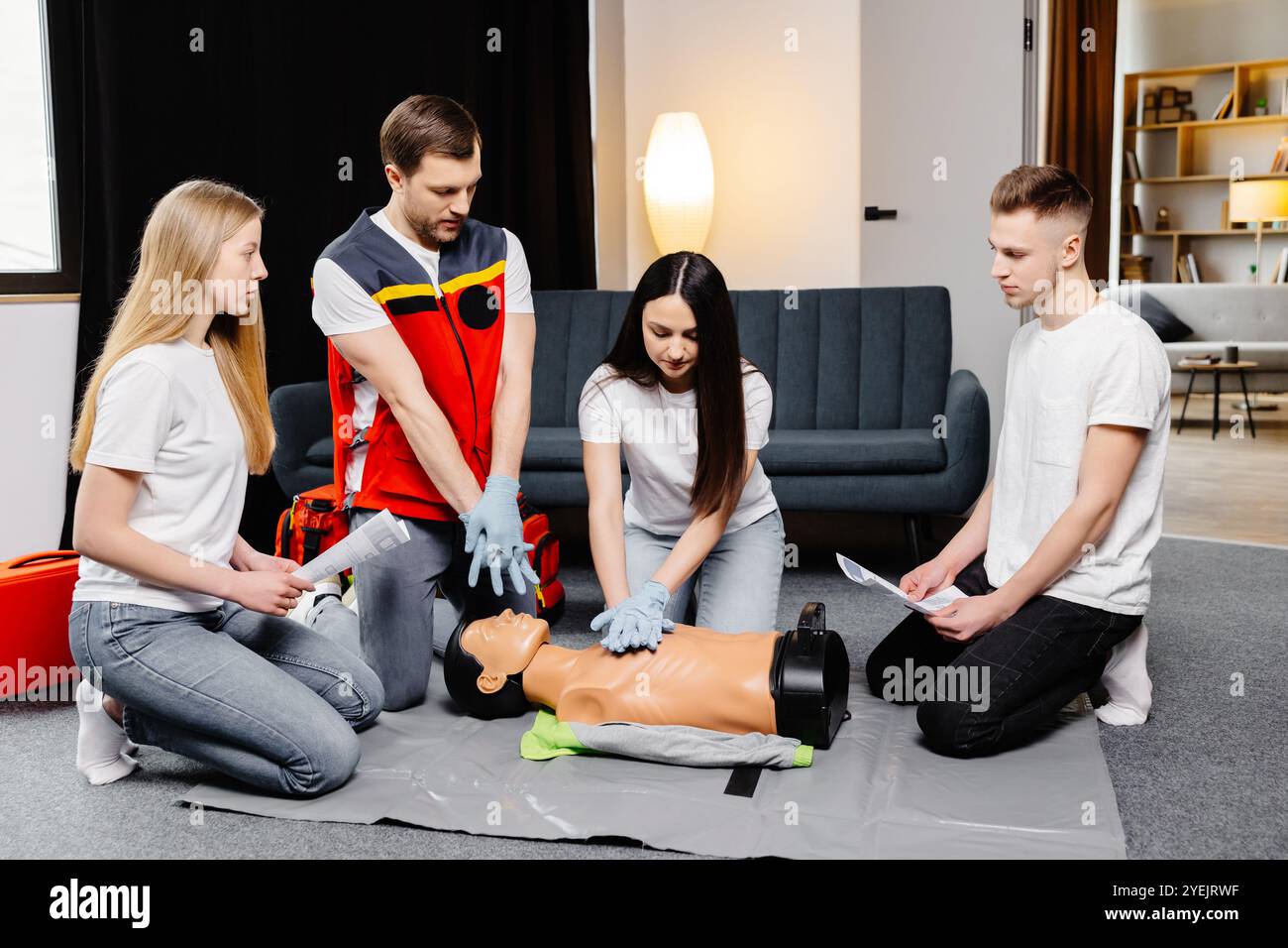 Group of people learning how to make first aid heart compressions with ...