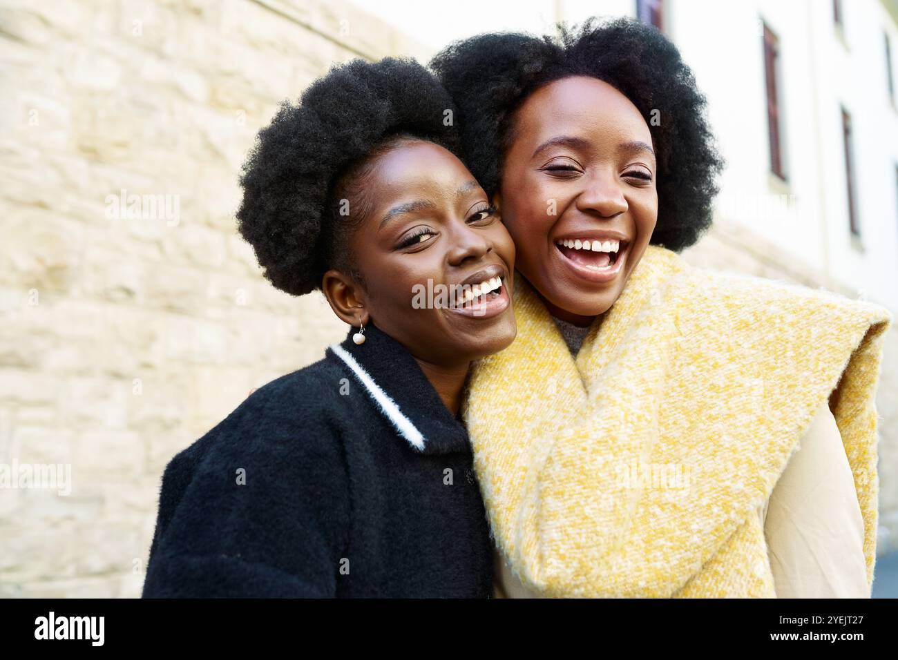 Joyful Friendship Moment: Two Women Laughing and Embracing in Urban ...