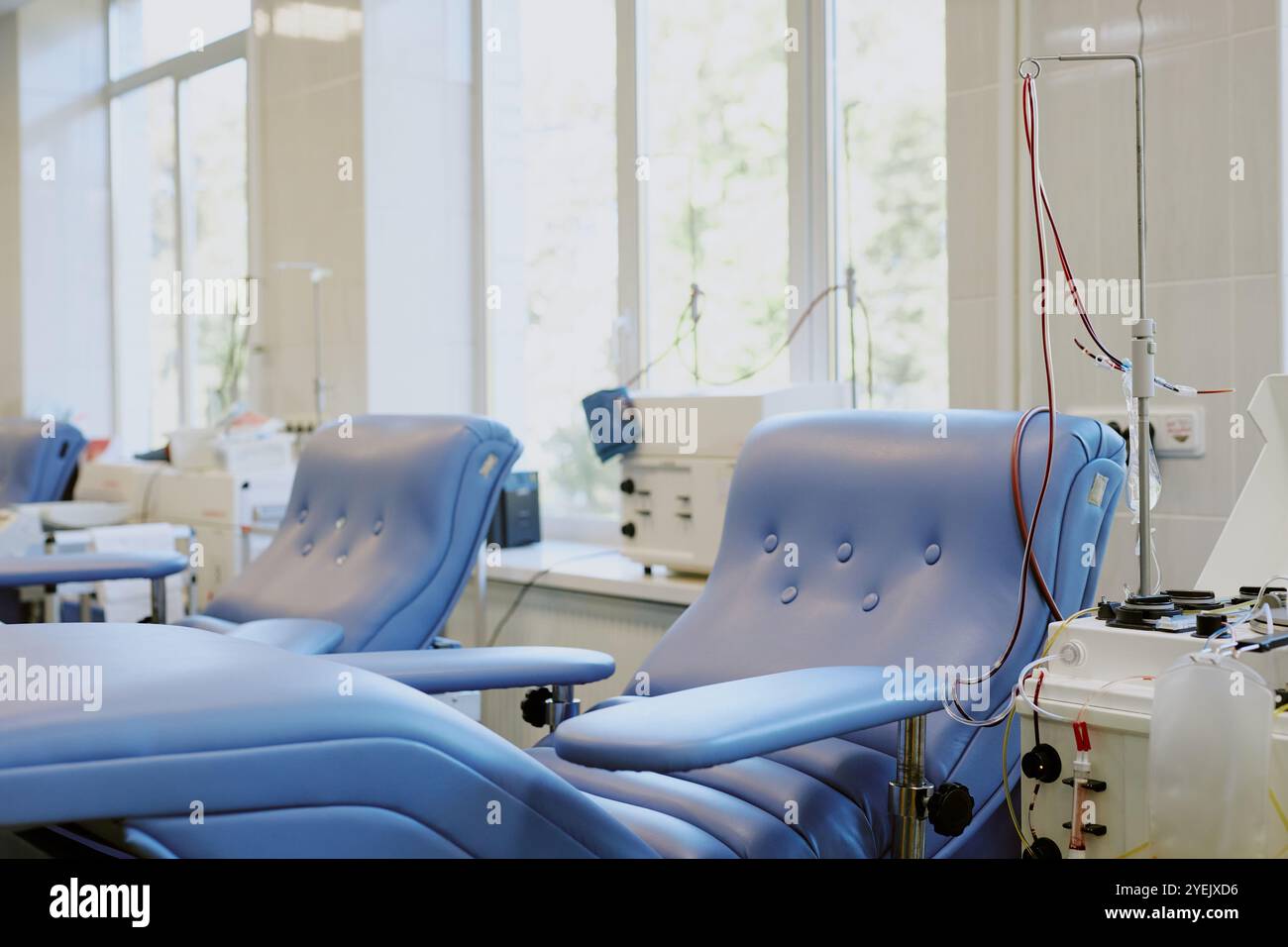 Empty treatment chairs lined up in a medical facility, with IV ...