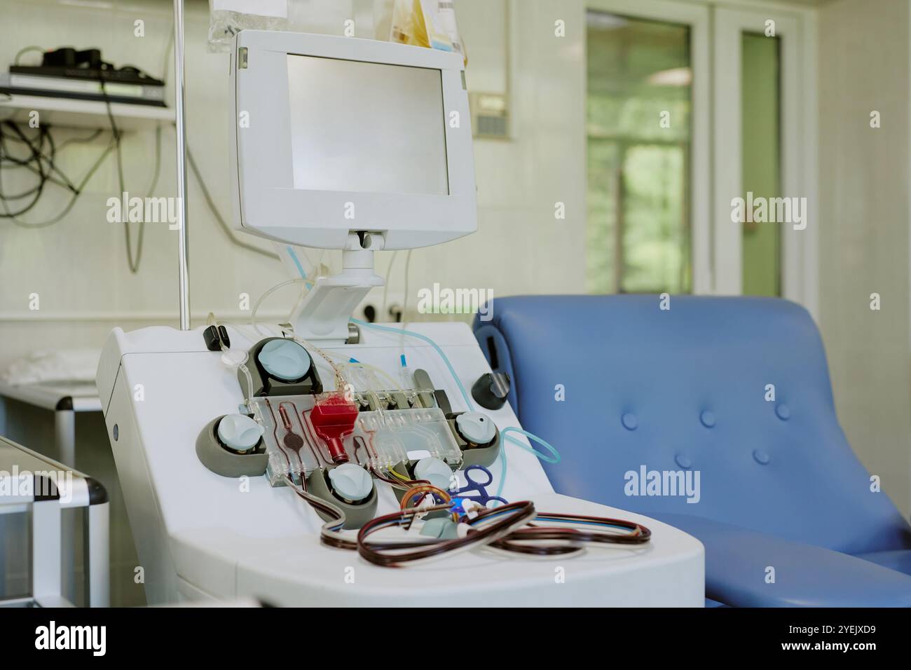 Medical tool with tubes and monitor placed next to a blue chair in ...