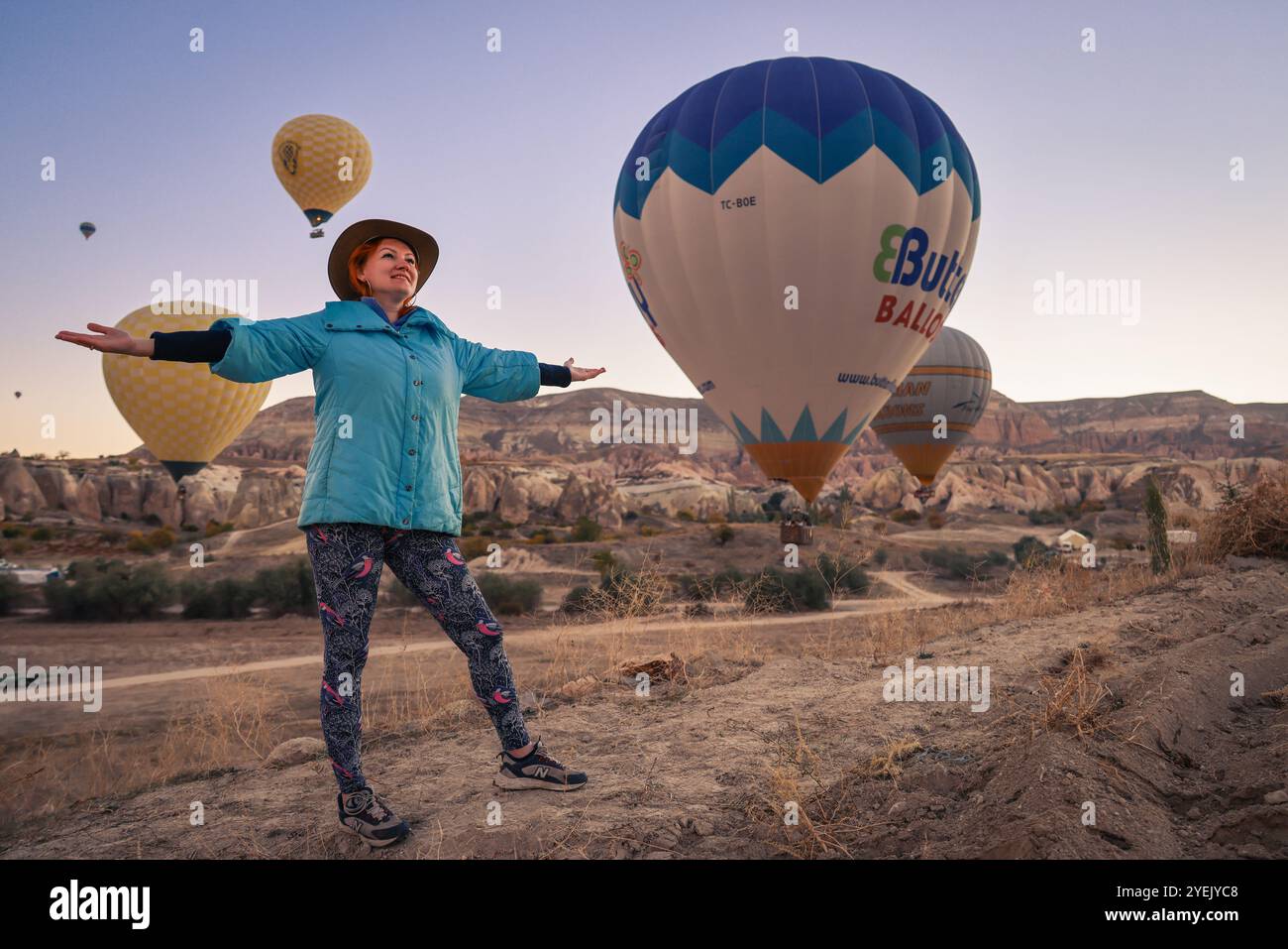 As the sun rises a traveler embraces the moment with open arms ...