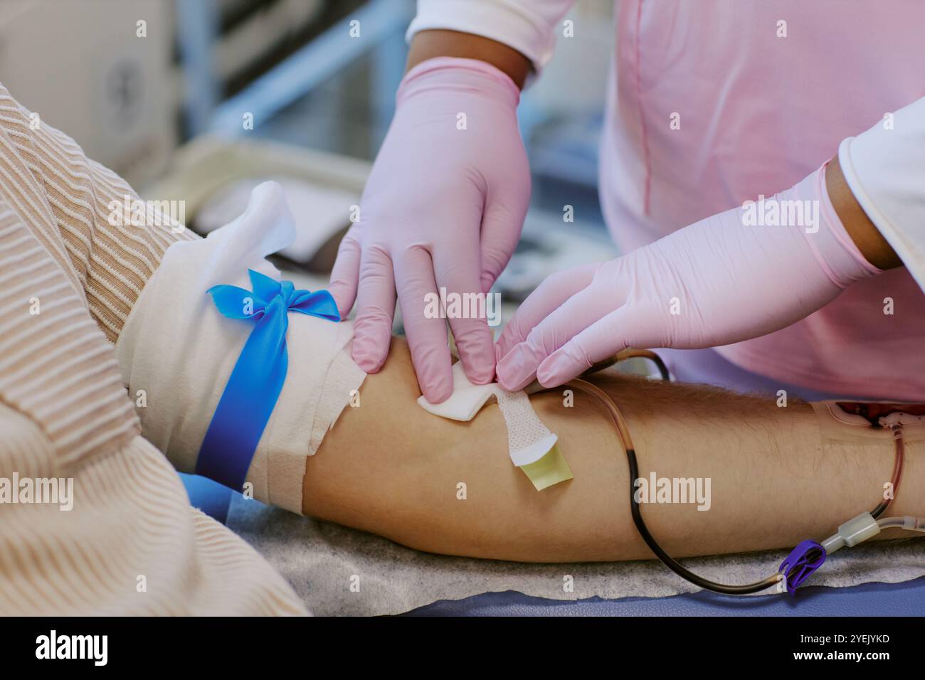 Medical professional wearing pink gloves taking blood sample from ...