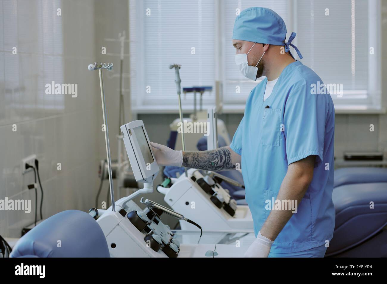 Medical professional in blue scrubs and surgical cap adjusting ...