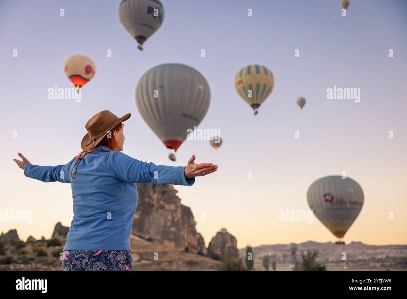 A traveler stands with arms outstretched embracing the beauty of ...