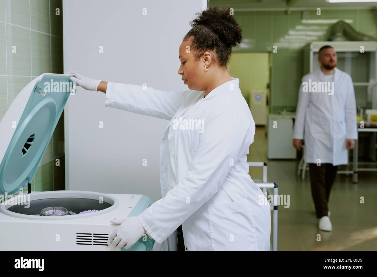 Scientist wearing laboratory coat handling equipment in modern lab ...