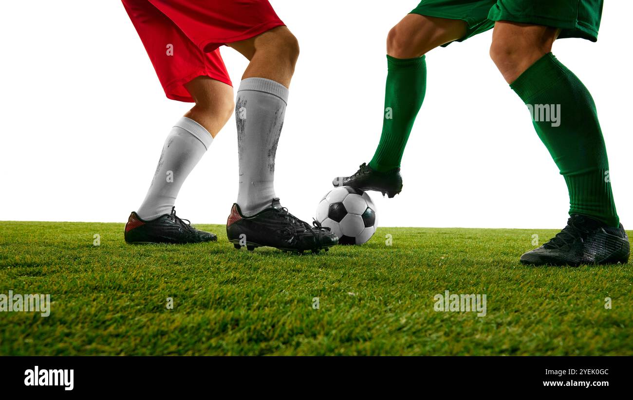 Two soccer players locked in close battle for control of ball on green ...