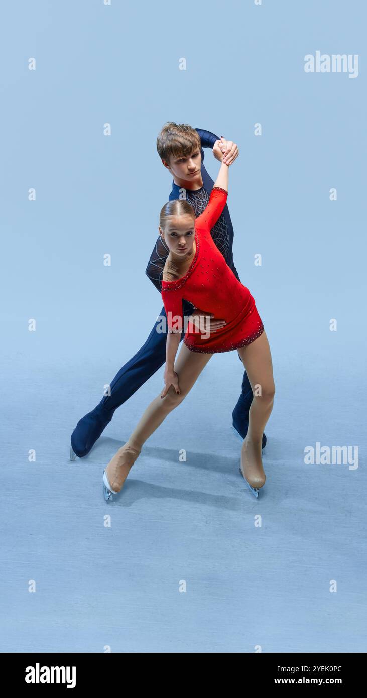 Pair of figure skaters performing dramatic extension on ice against ...
