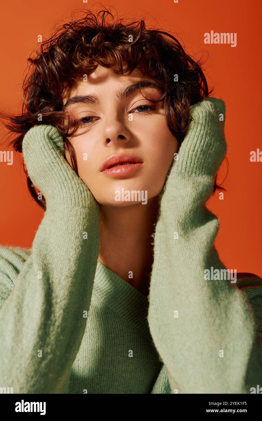 A young woman exudes emotion while resting her hands on her face ...