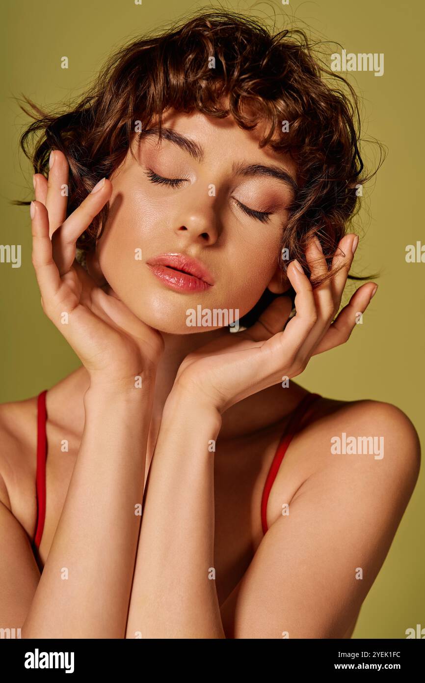 A young woman expresses deep emotion, gently holding her face ...