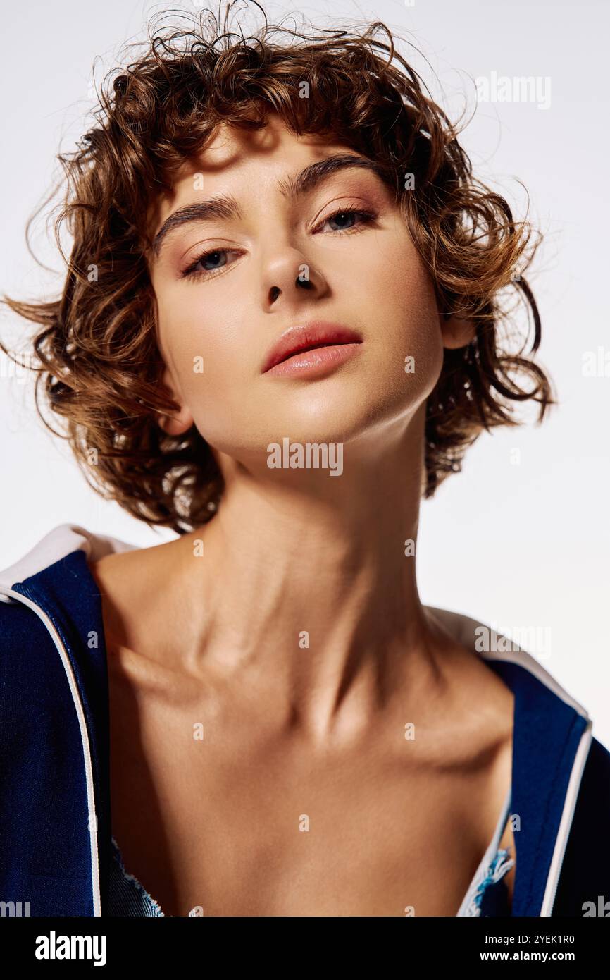 A young woman with curly hair captures the viewers attention with her intense expression and ...