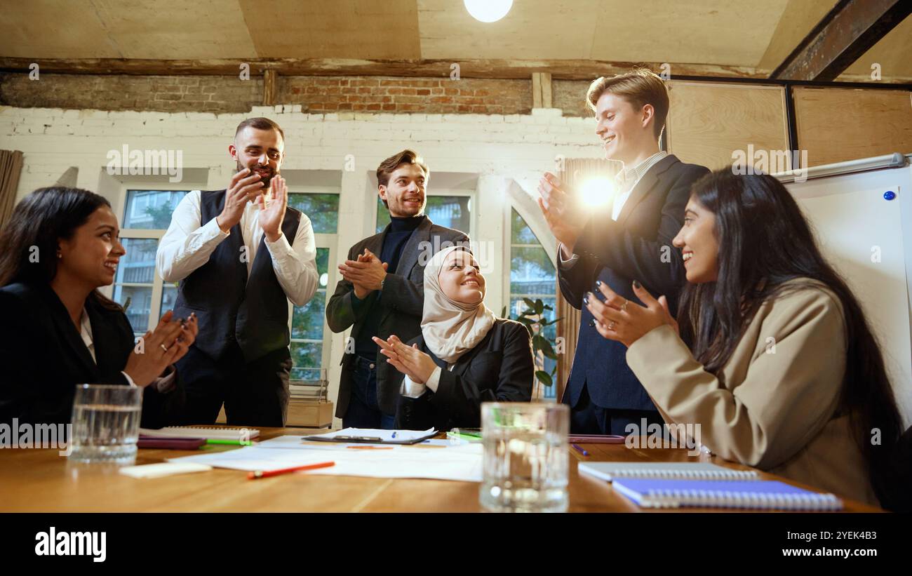 Colleagues clap in appreciation after business presentation on global ...