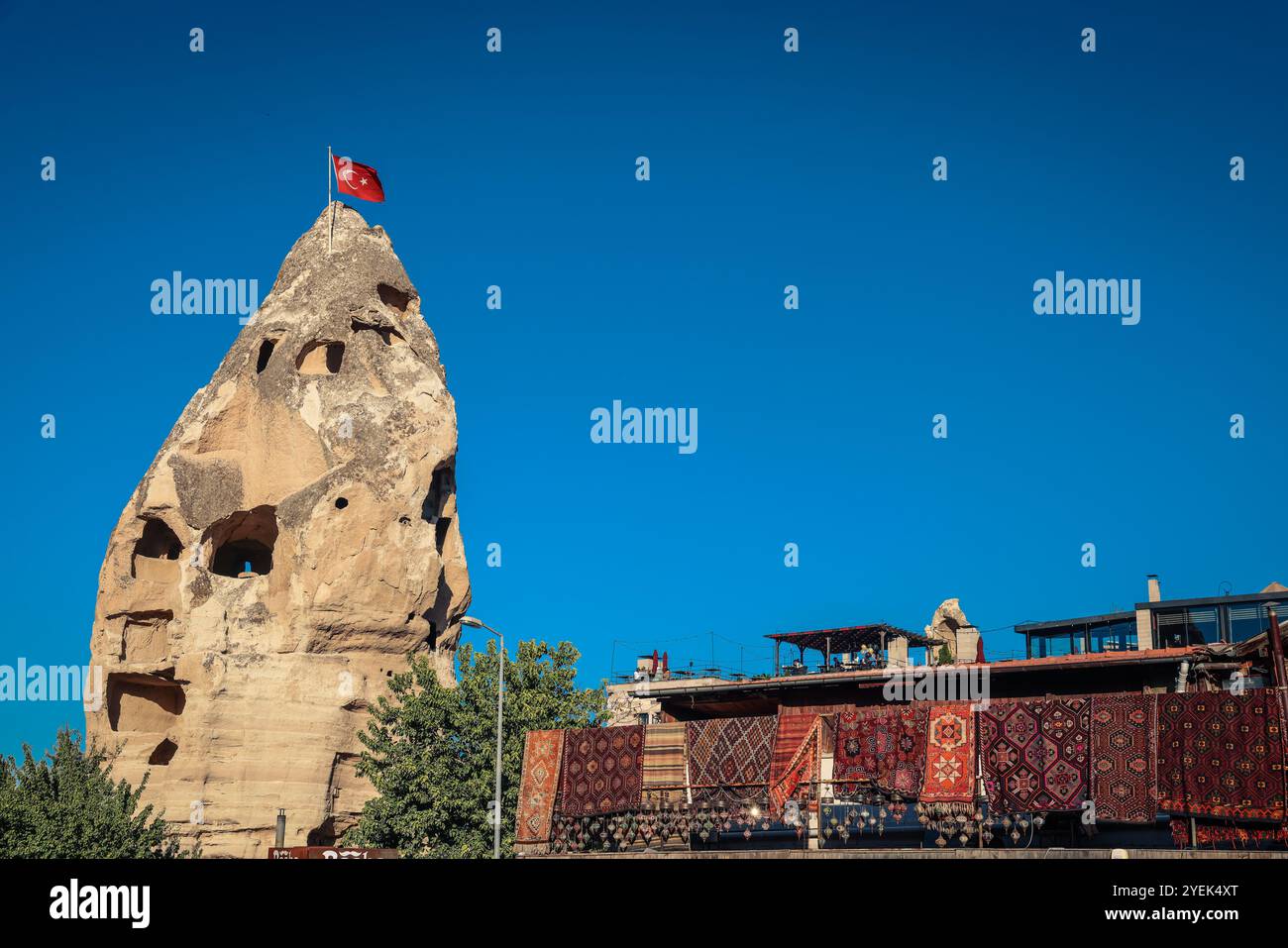 A unique rock formation towers over local shops in Cappadocia with the ...