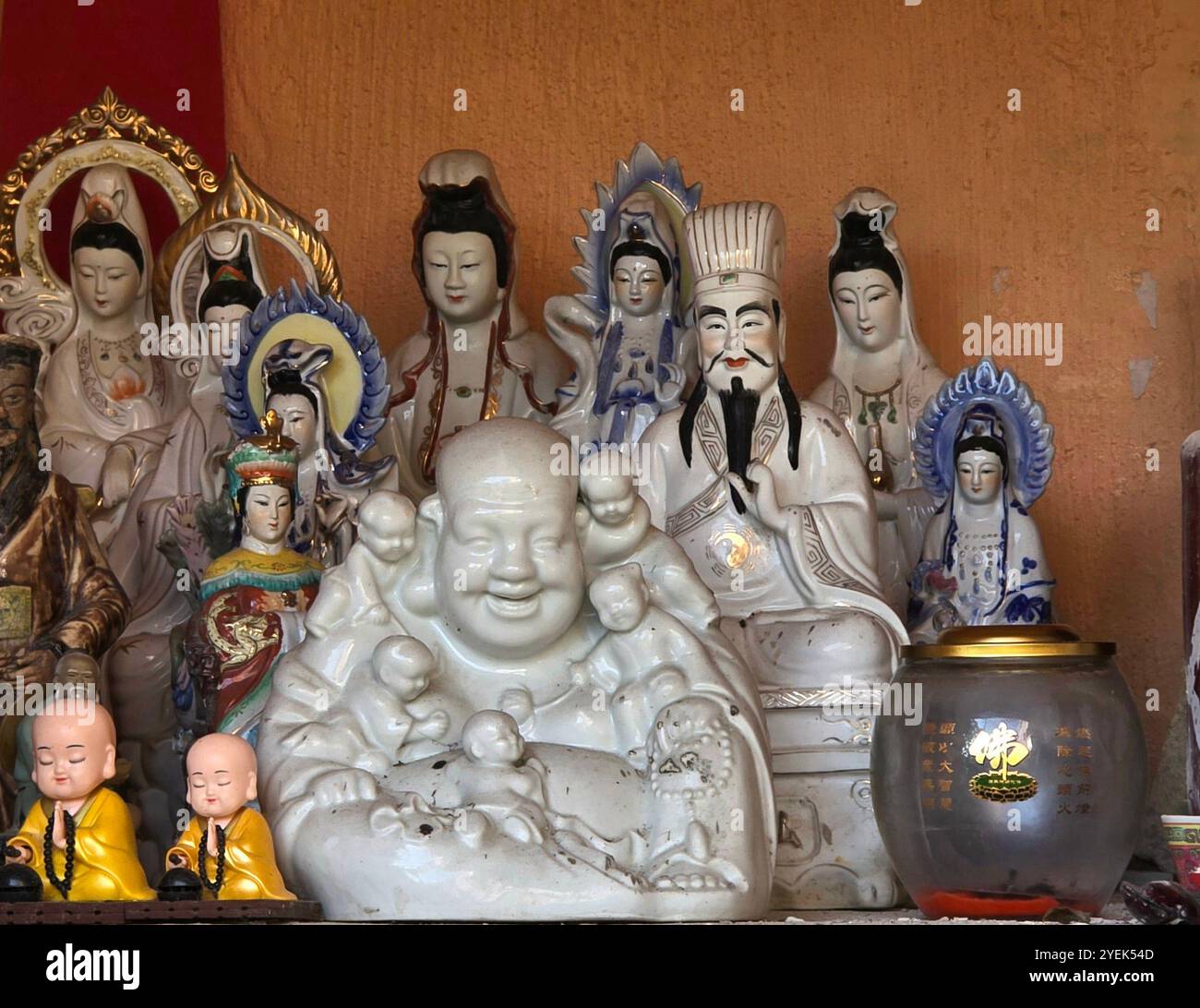 A laughing Buddha and other religous figures in a small temple in Tai ...