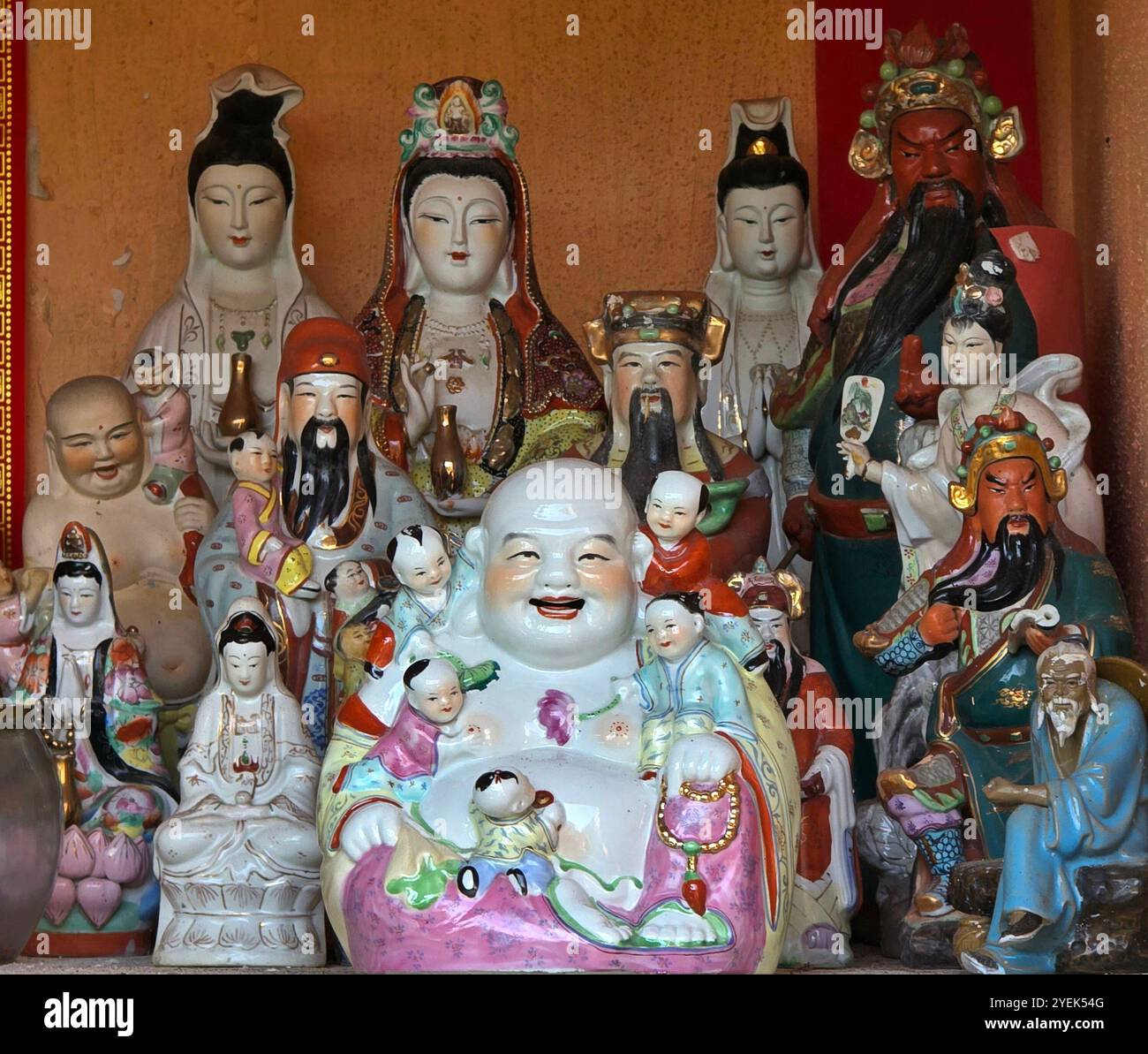 A laughing Buddha and other religous figures in a small temple in Tai ...